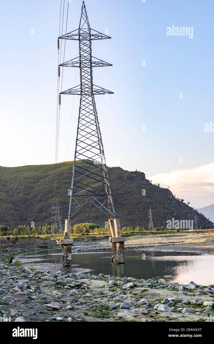 Electrical tower stands after heavy field washout the soil from its ...