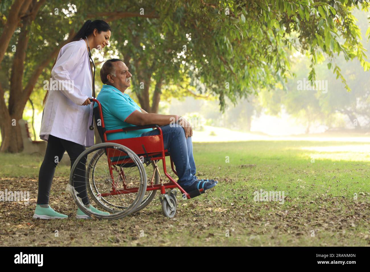 Female Doctor taking care of senior patient in hospital garden. The ...