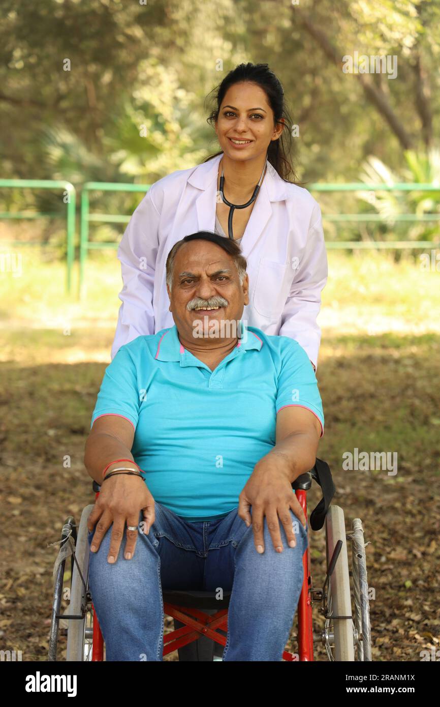 Female Doctor taking care of senior patient in hospital garden. The ...