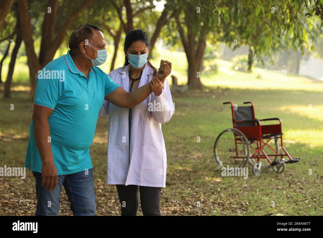 Female Doctor taking care of senior patient in hospital garden. The ...
