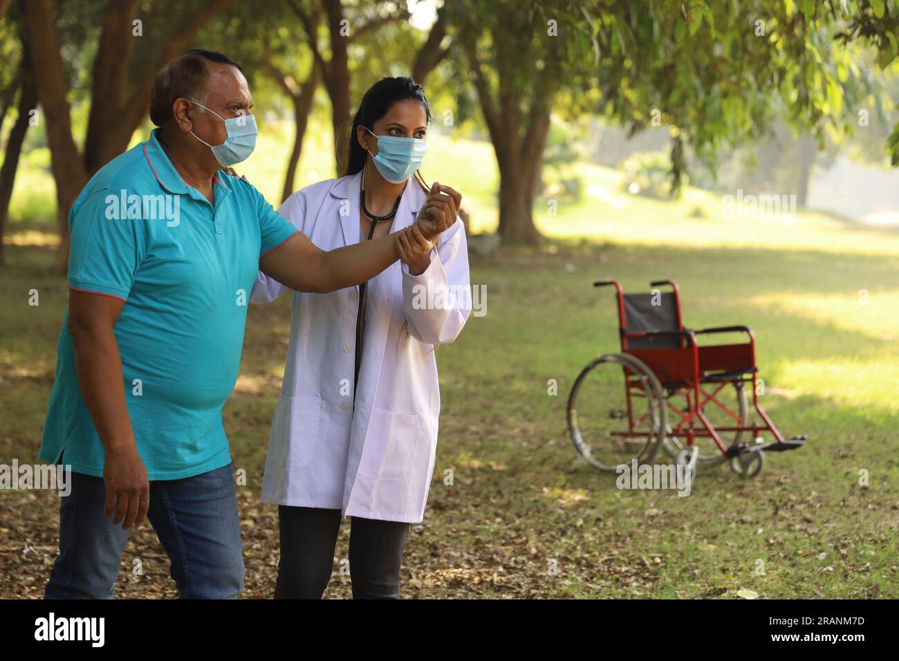 Female Doctor taking care of senior patient in hospital garden. The ...
