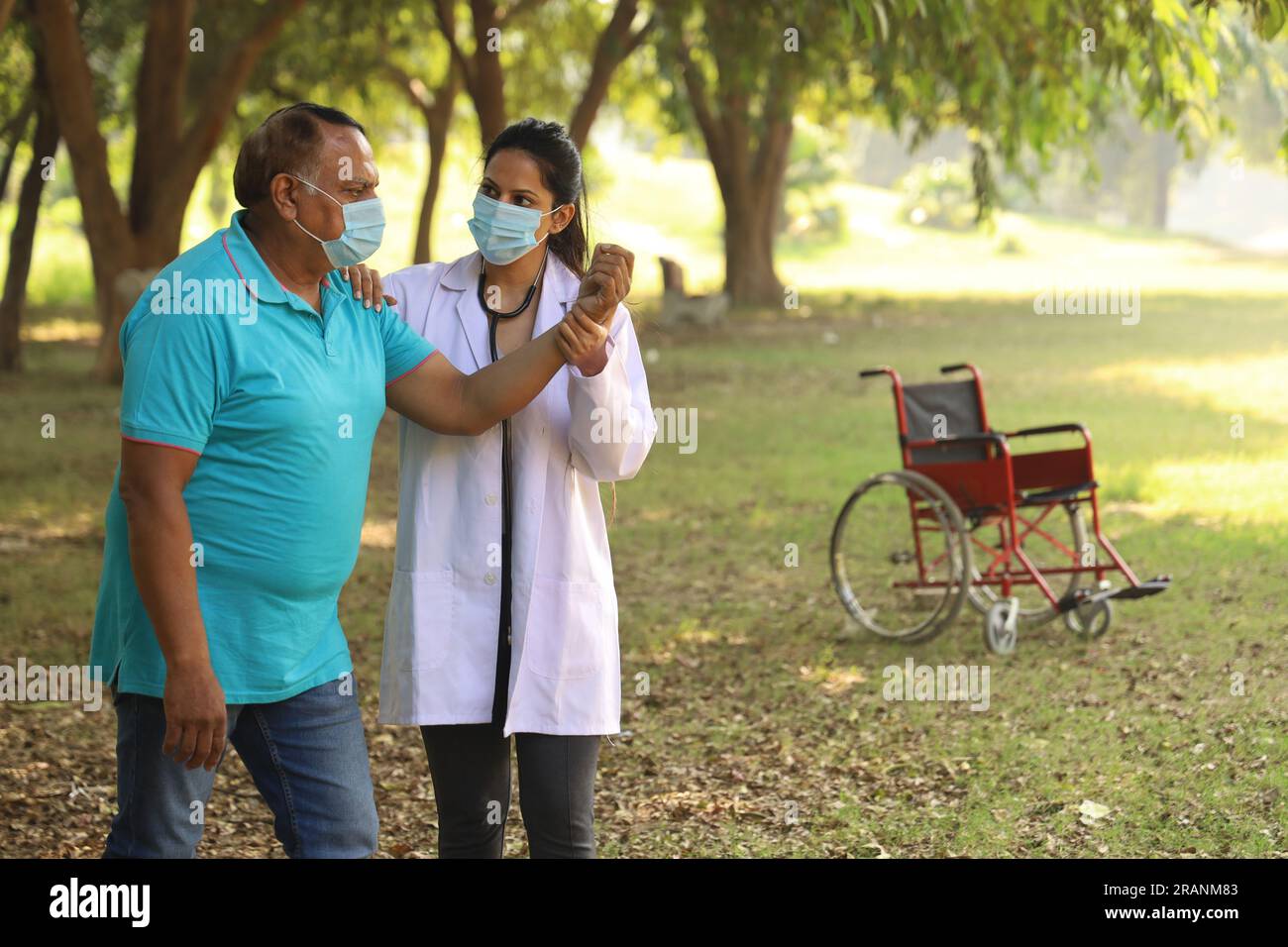 Female Doctor taking care of senior patient in hospital garden. The ...
