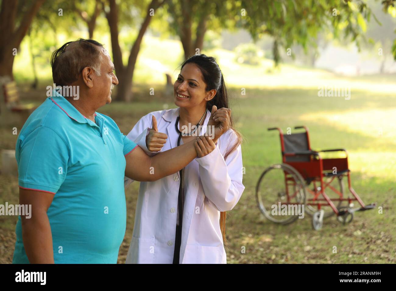Female Doctor taking care of senior patient in hospital garden. The ...