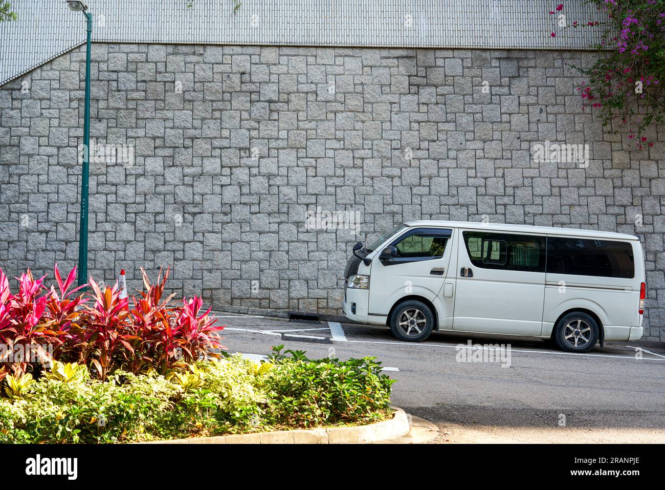 A white classic van parked on the half slope of the street in Hong Kong ...