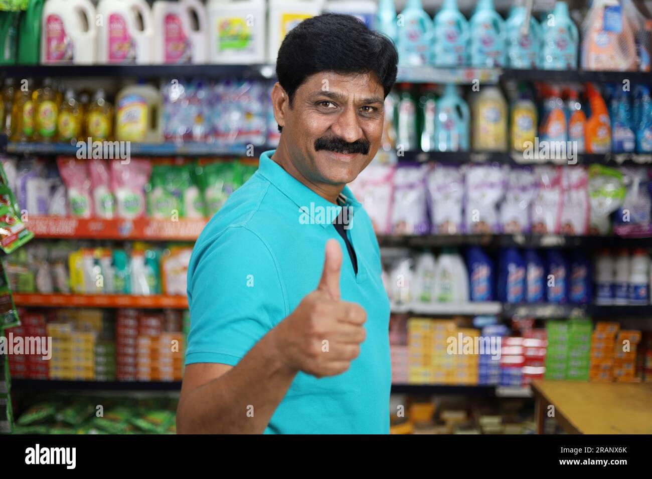Smiling Indian mid aged man purchasing in a grocery store. Buying ...