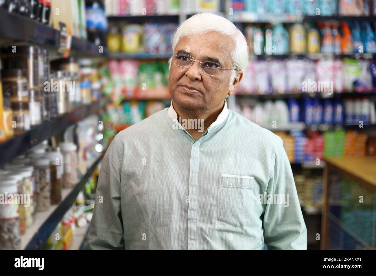 Old man standing in front of product shelf in grocery store. Confused ...