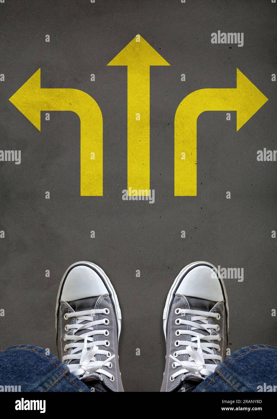 Feet standing on a street mark of yellow arrow pointing in three ...