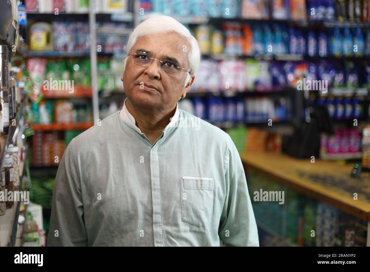 Old man standing in front of product shelf in grocery store. Confused ...