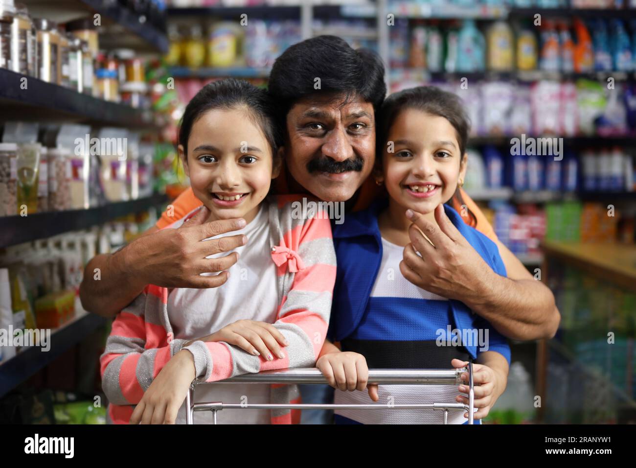 portrait of Indian happy father shopping in a hypermarket with kids ...