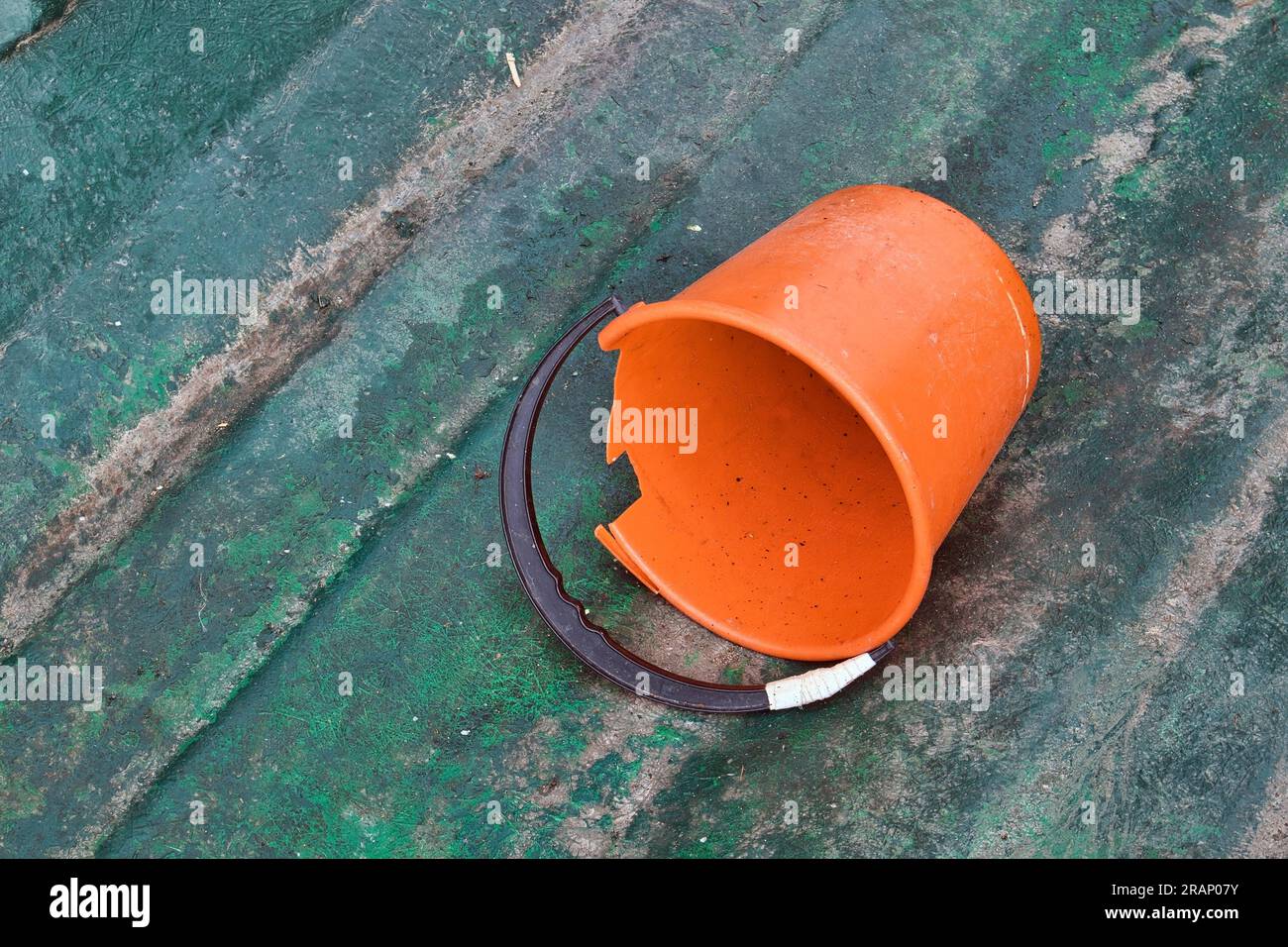 old orange plastic bucket in a weathered green fibreglass boat Stock ...