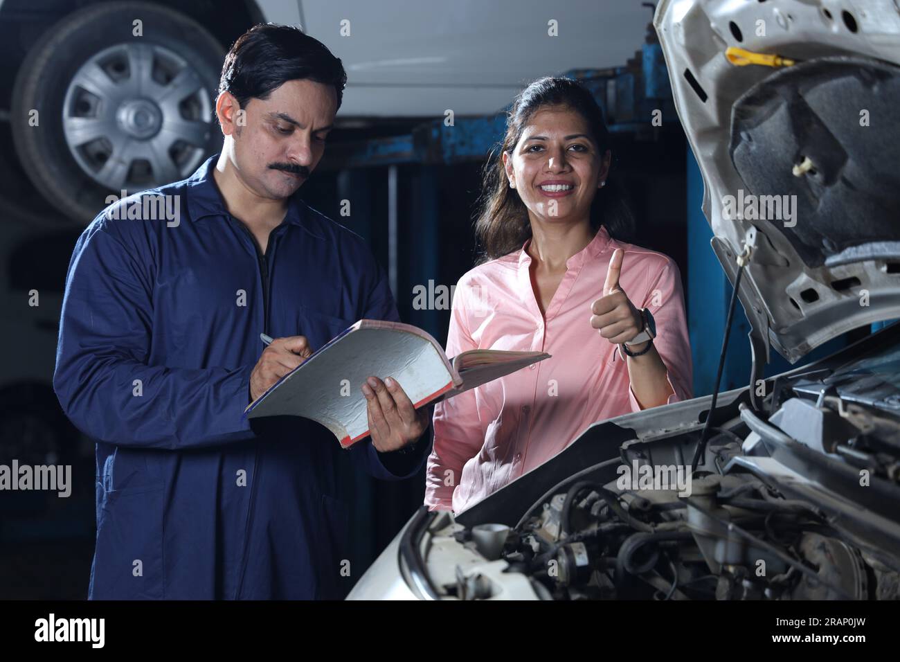Happy female customer showing thumbs up for repairing her car on time ...