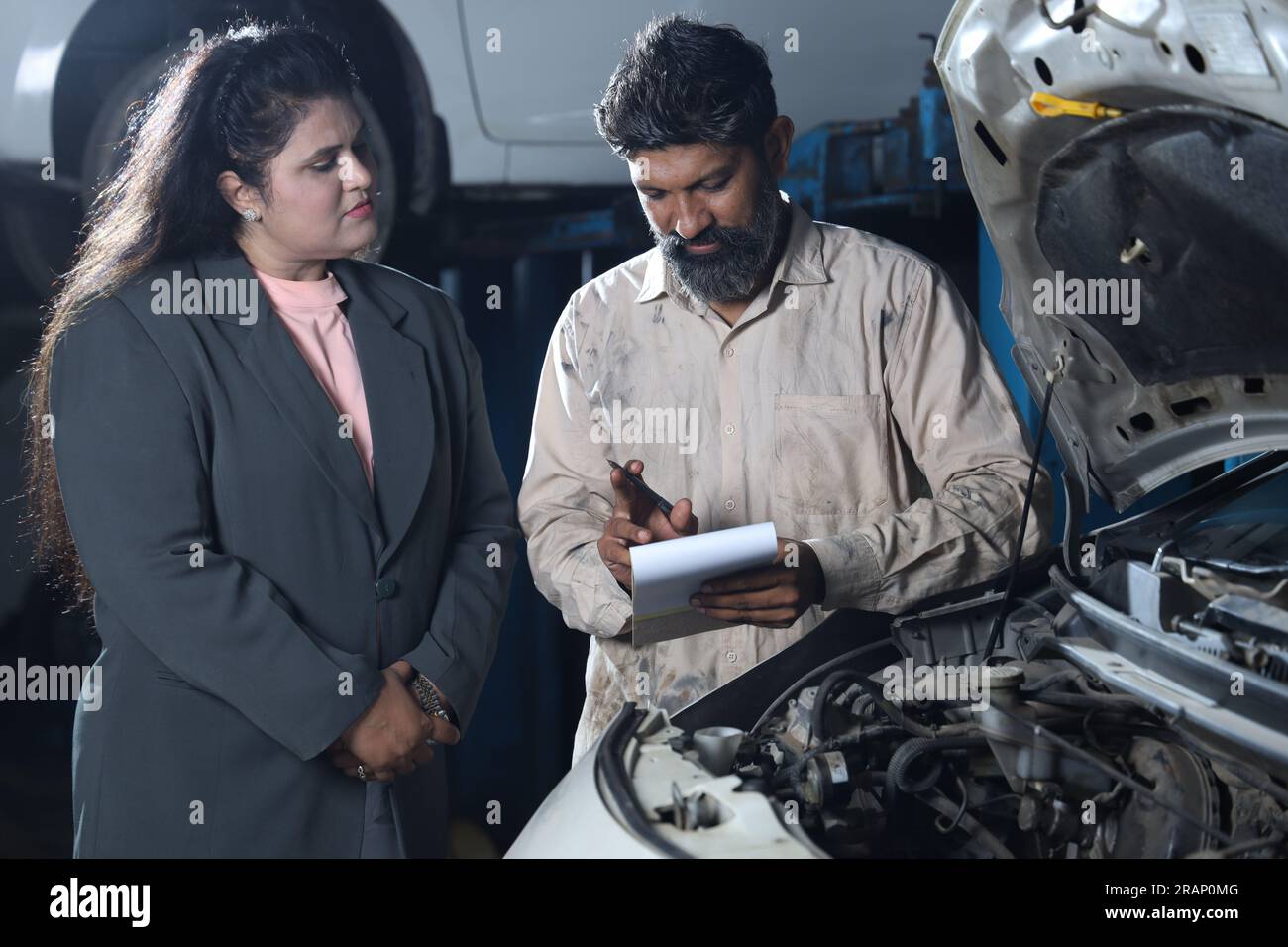 Happy customer shaking hands with mechanics hi-res stock photography ...