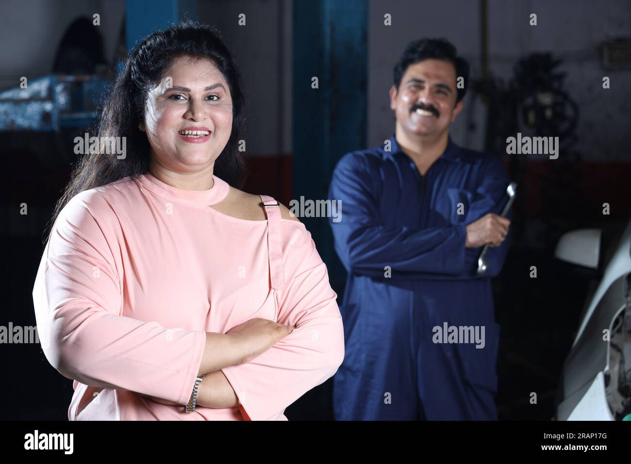 Happy Indian female customer in a car repairing shop portraying ...
