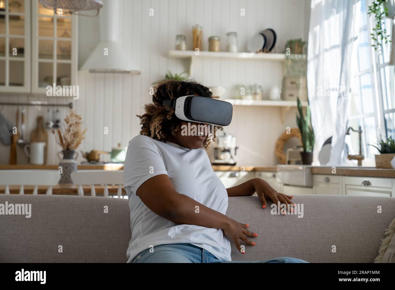 Shocked surprised young black woman sitting on sofa feeling scared in ...