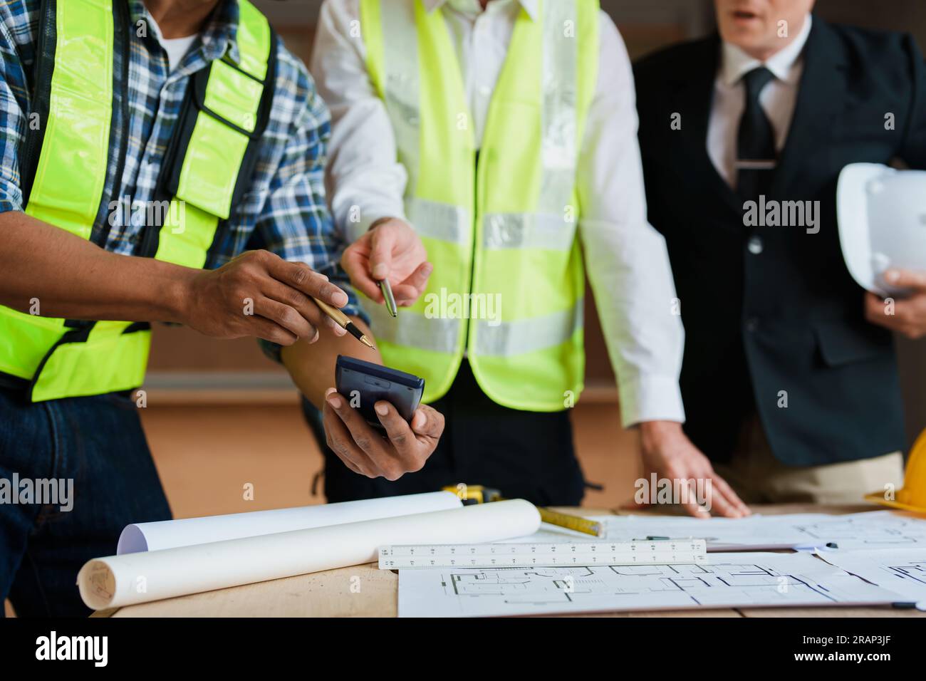 multi ethnic engineer brainstorming and measuring for cost estimating ...