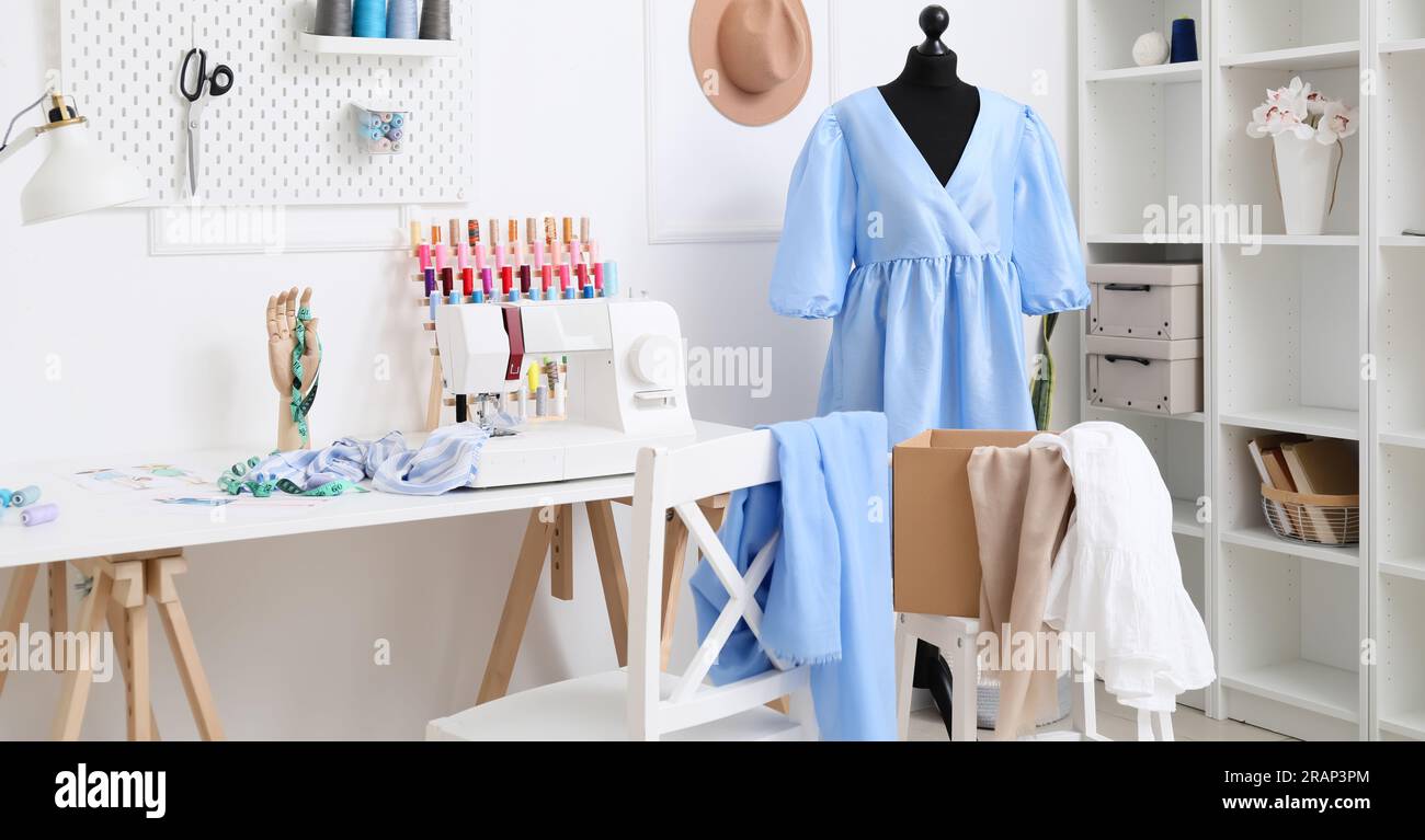 Interior of modern atelier with tailor's workplace, mannequin and ...