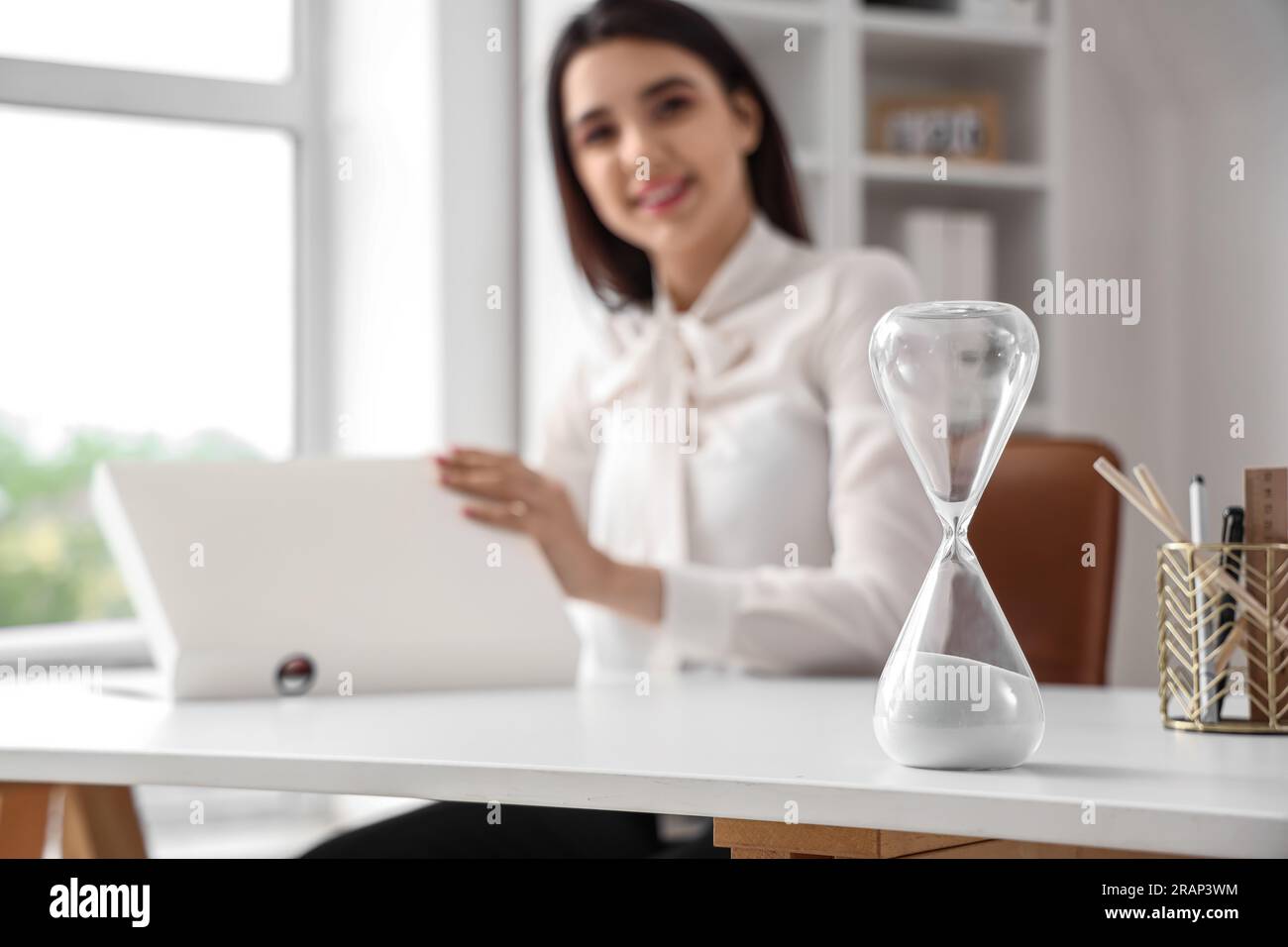 Hourglass on table of businesswoman in office. Time management concept ...
