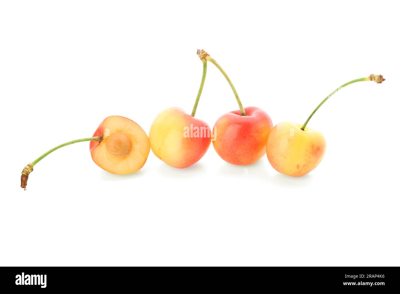 Sweet yellow cherries with half on white background Stock Photo - Alamy