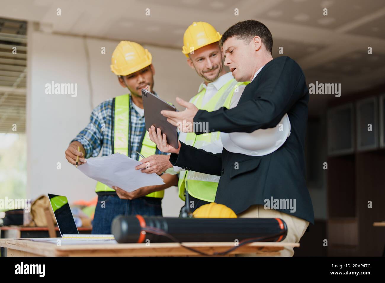 multi ethnic engineer brainstorming and measuring for cost estimating ...