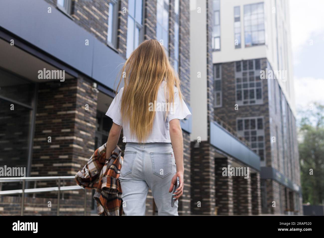young woman walks down the street, back view Stock Photo - Alamy