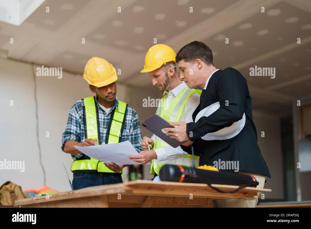 multi ethnic engineer brainstorming and measuring for cost estimating ...