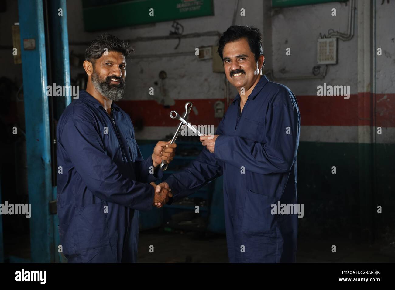 Portrait of happy Indian car mechanics standing together in service ...