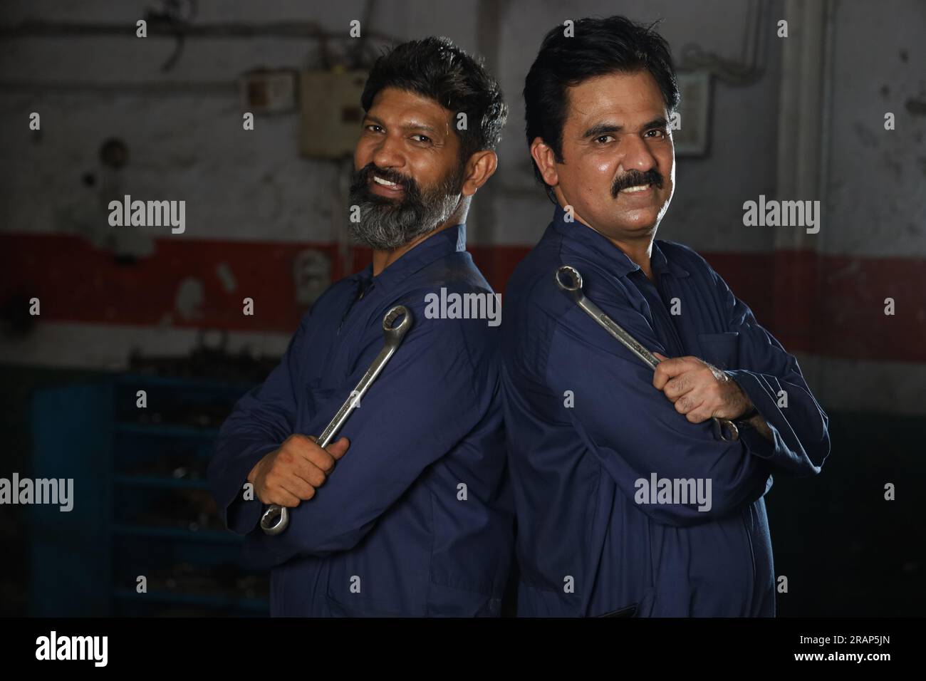 Portrait of happy Indian car mechanics standing together in service ...