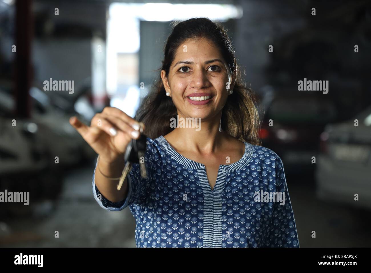 Indian happy customer giving the car keys to the mechanic. Portraying ...