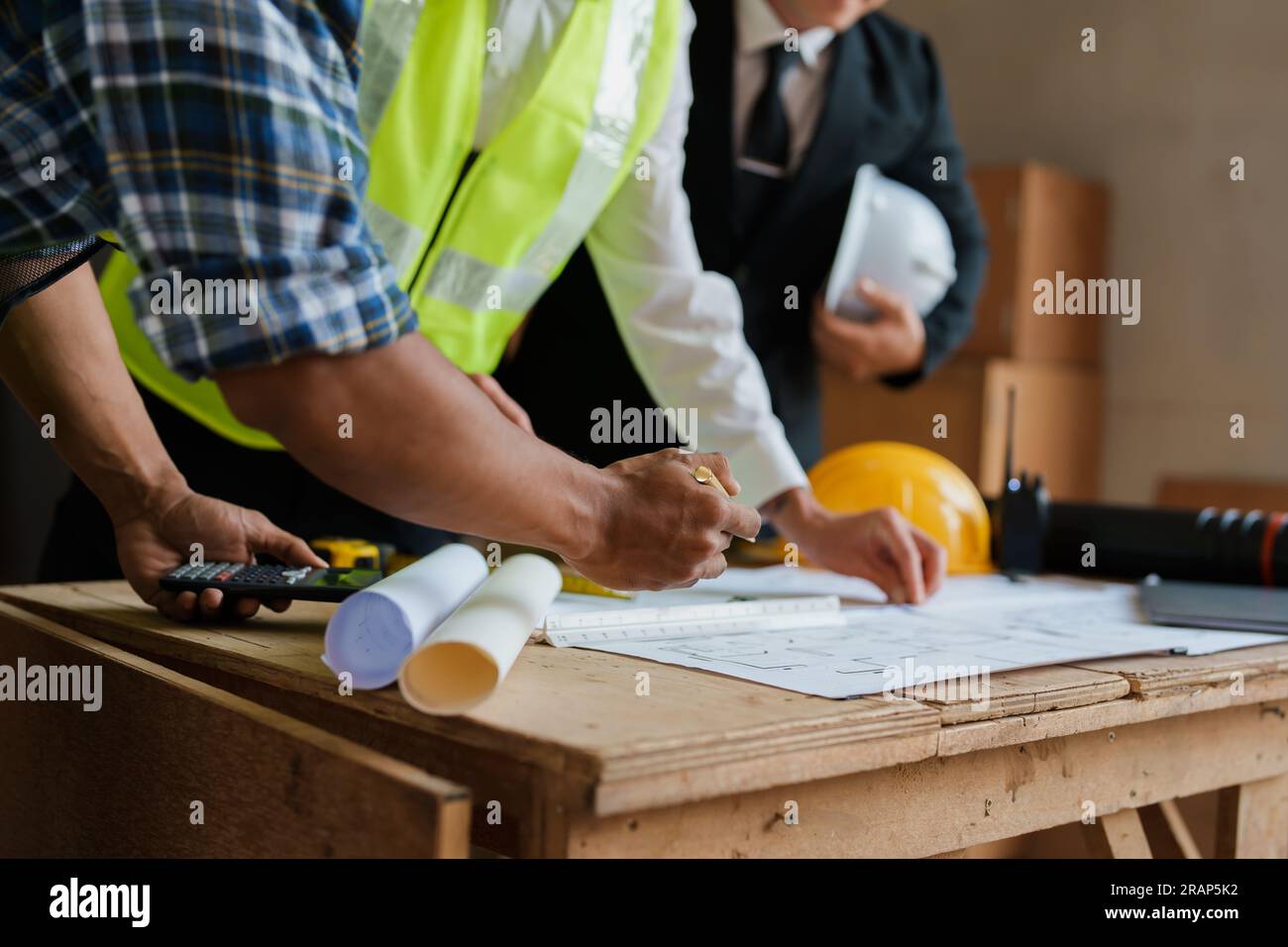 multi ethnic engineer brainstorming and measuring for cost estimating ...