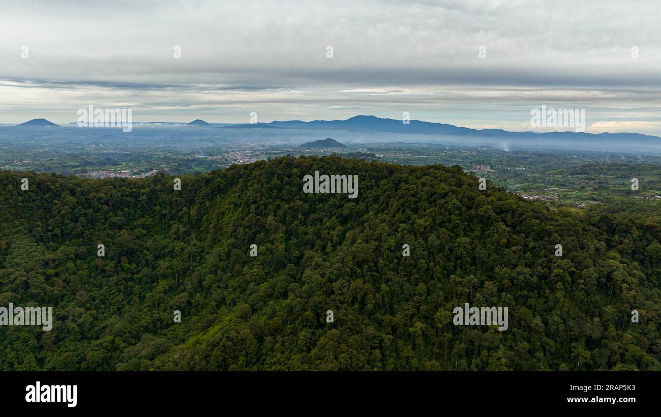 Aerial view of Berastagi city among mountains and farmland in a ...