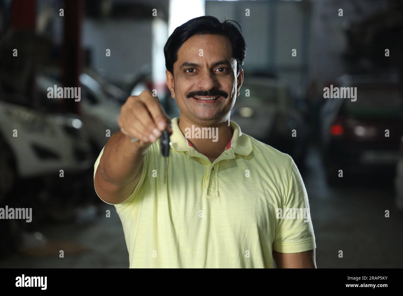 Indian happy customer giving the car keys to the mechanic. Portraying ...