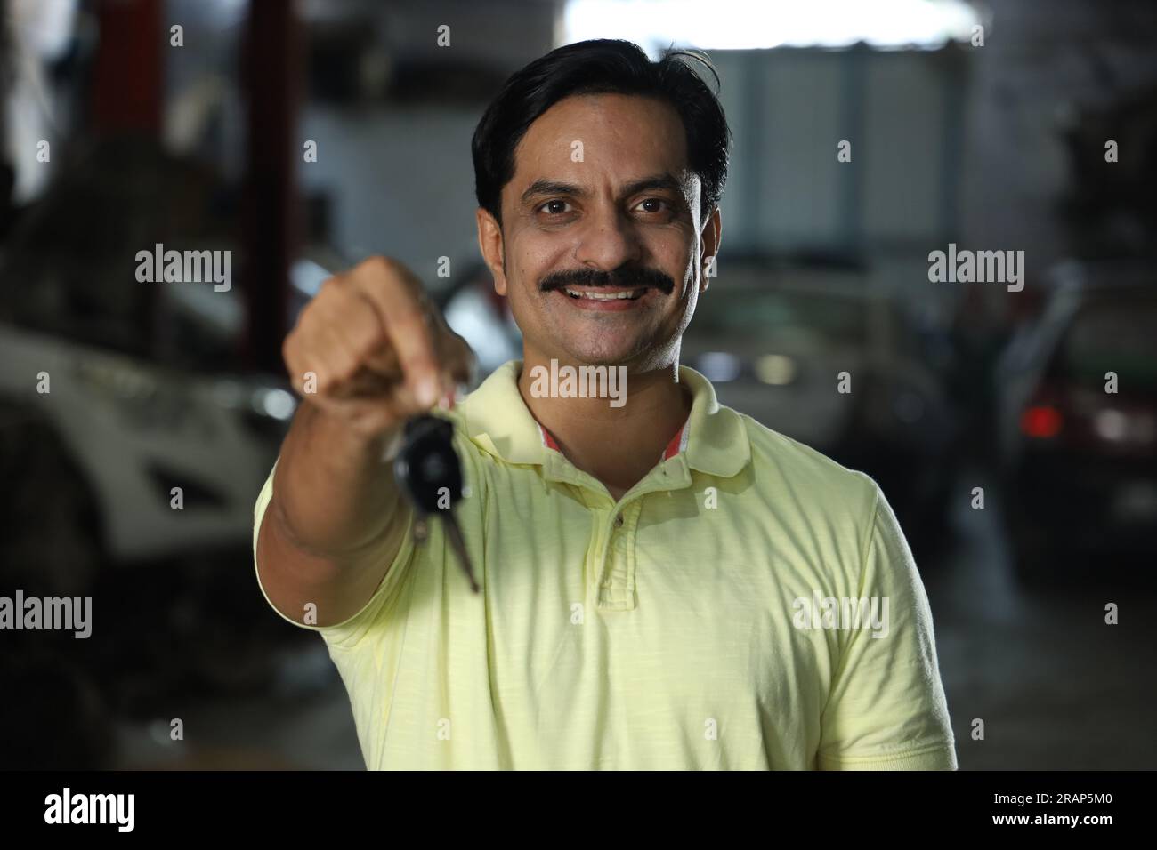 Indian happy customer giving the car keys to the mechanic. Portraying ...