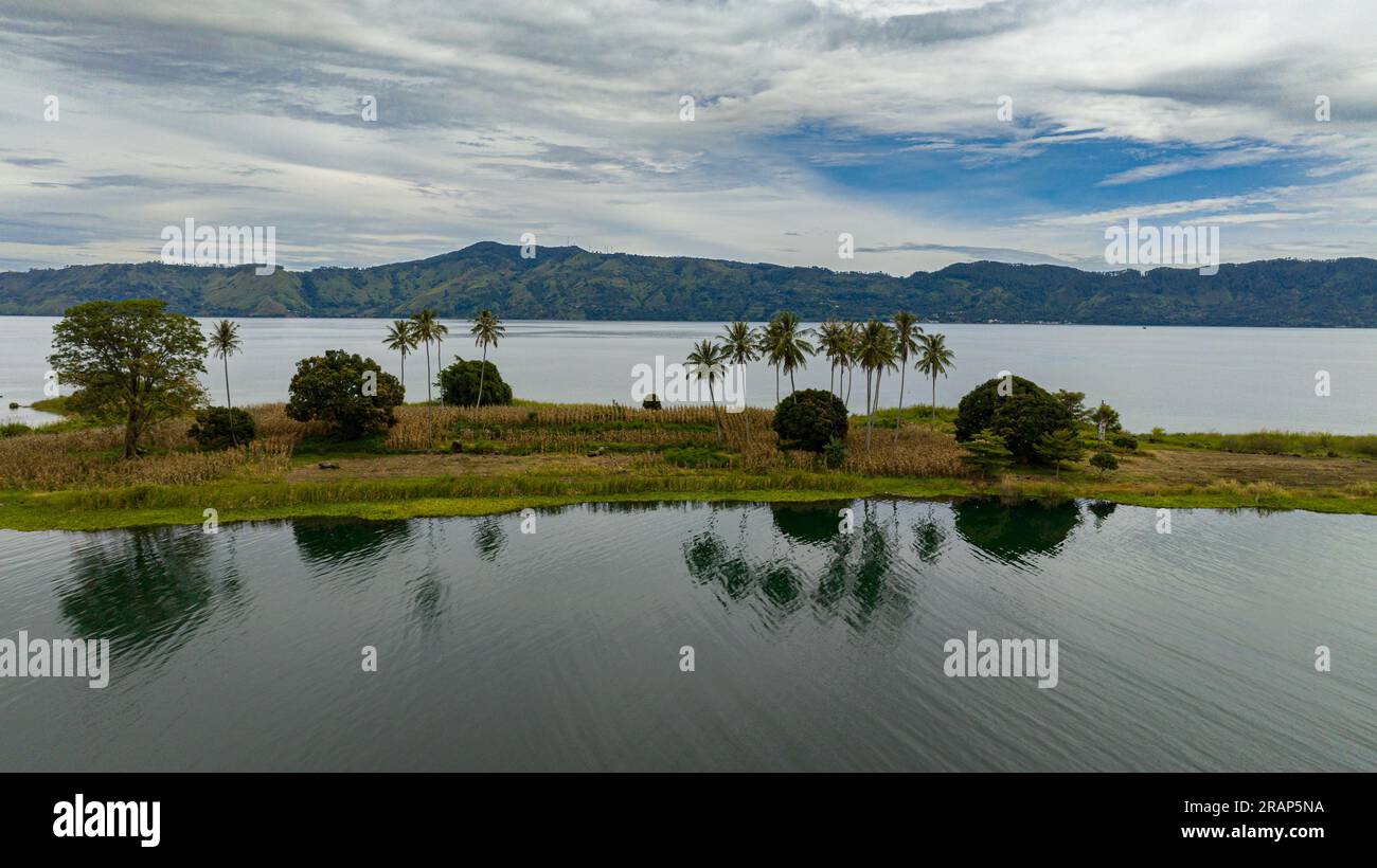Aerial view of beautiful Lake Toba and an island with palm trees ...