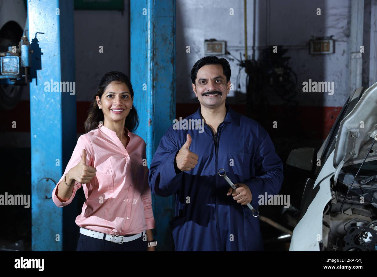 car mechanic standing with the happy customer shaking hands together ...