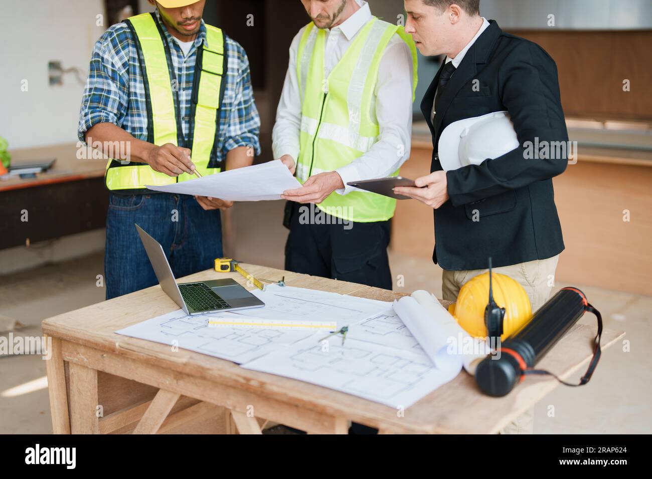 multi ethnic engineer brainstorming and measuring for cost estimating ...