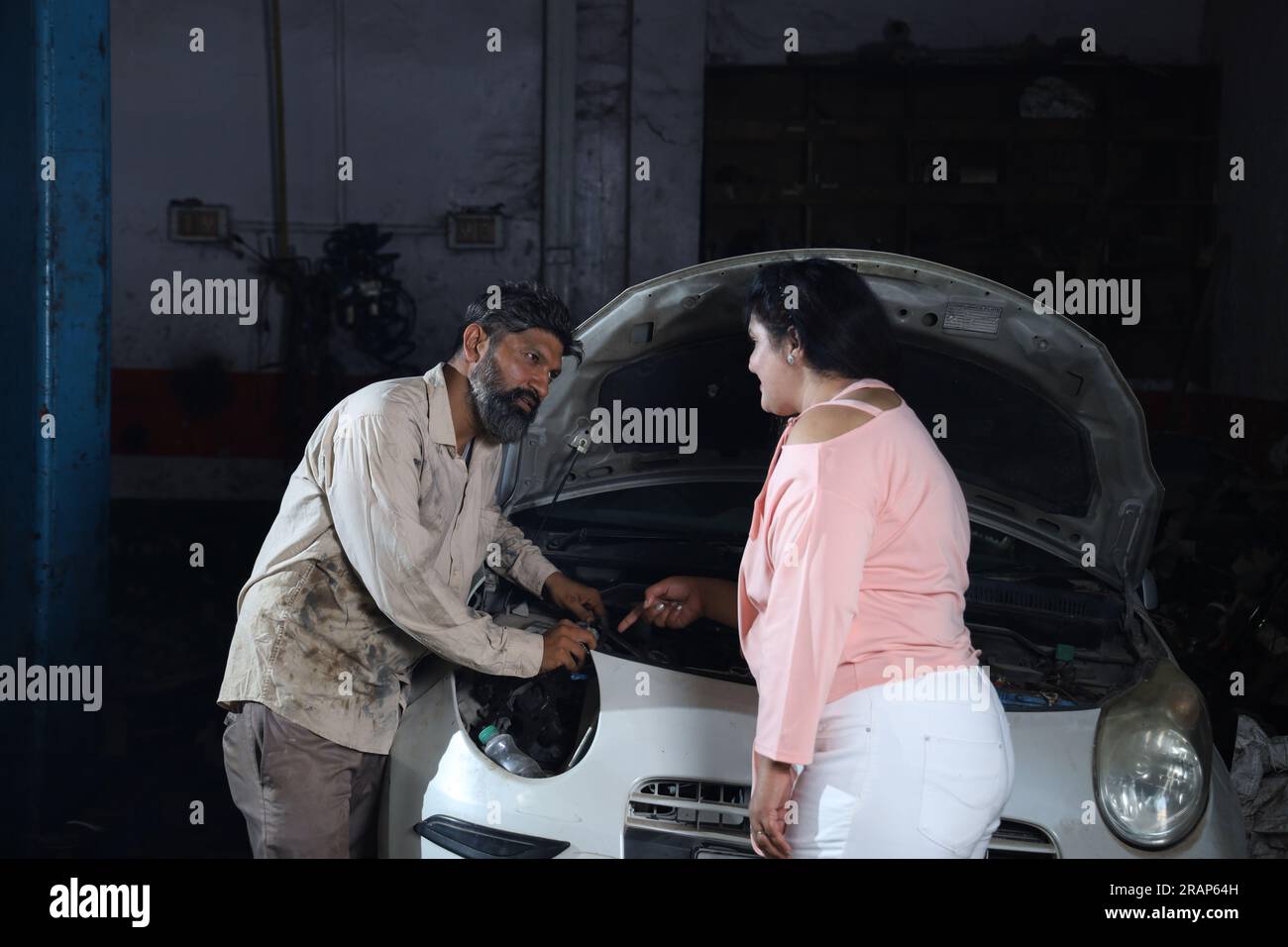 car mechanic standing with the happy customer shaking hands together ...