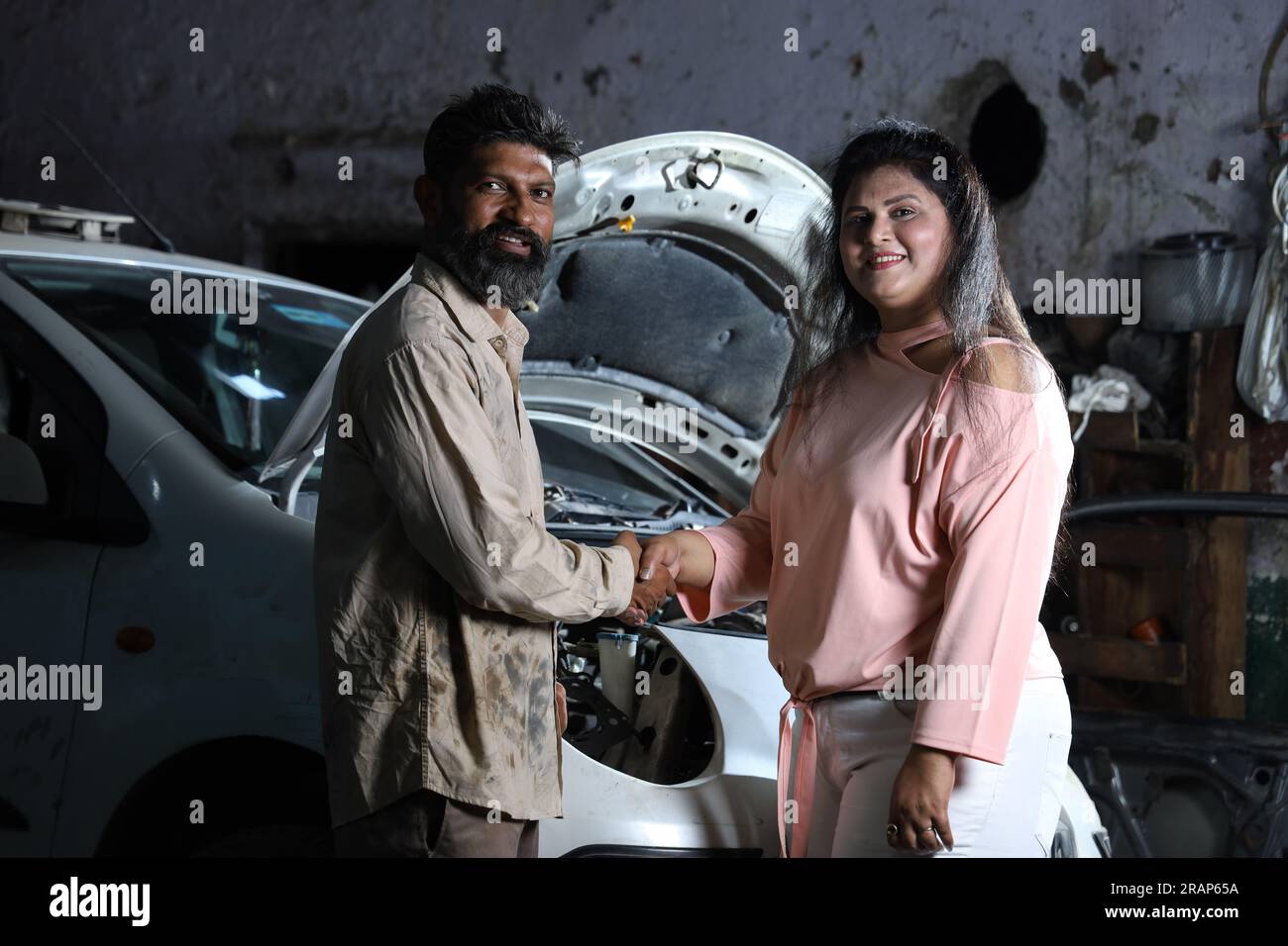 car mechanic standing with the happy customer shaking hands together ...