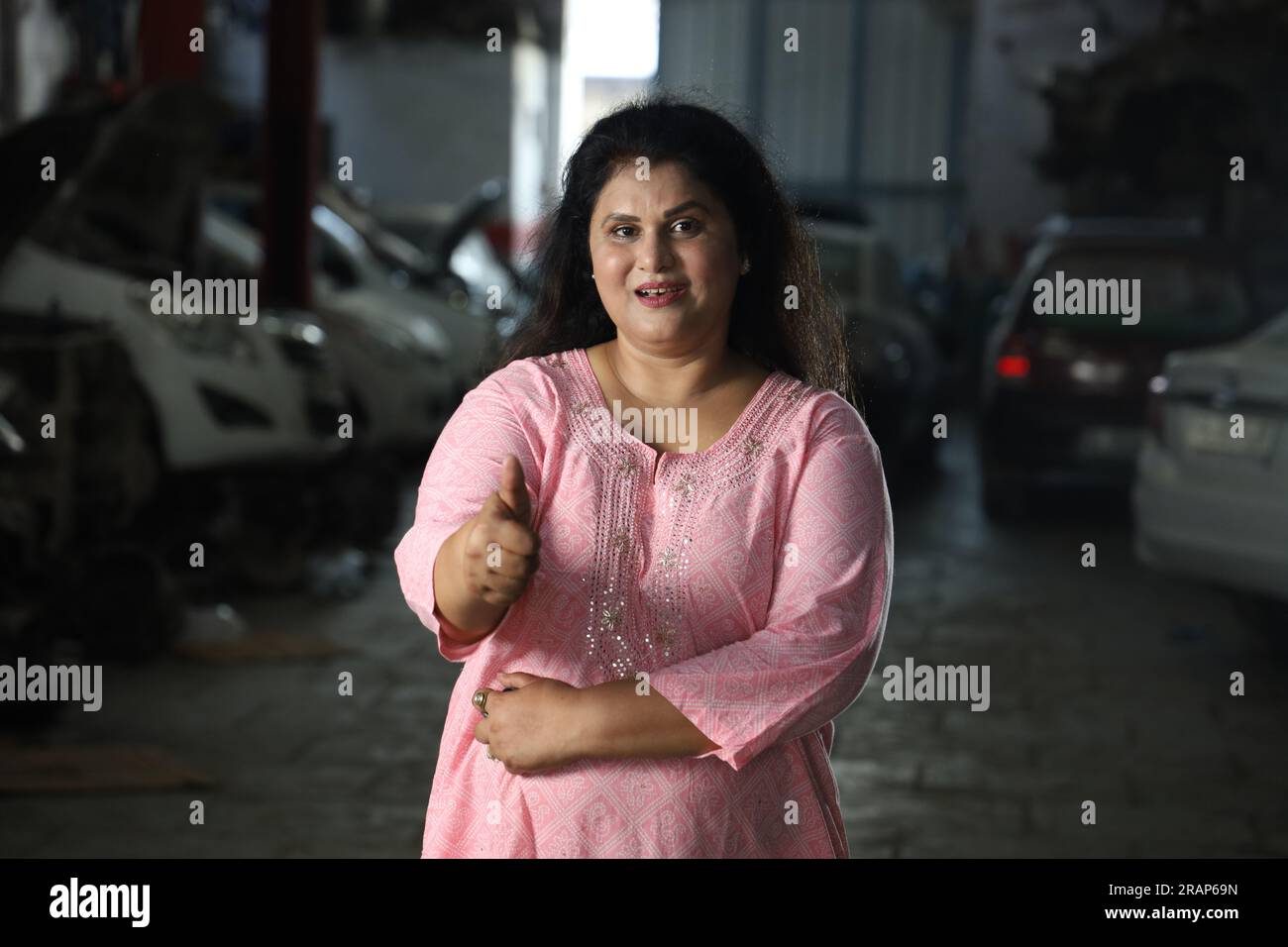 Indian happy female customer showing a thumbs up for repairing the car ...