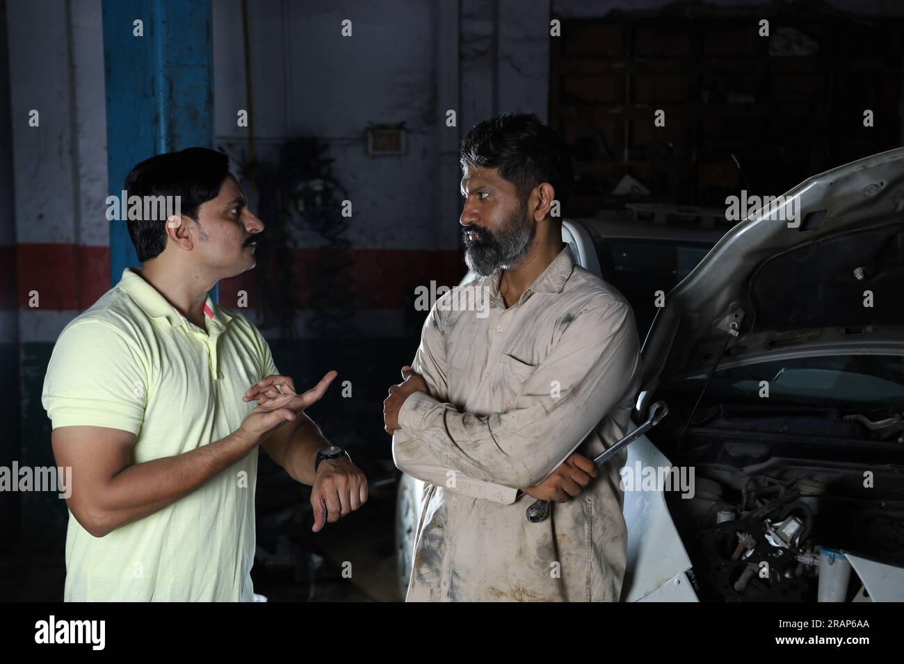 car mechanic standing with the happy customer shaking hands together ...