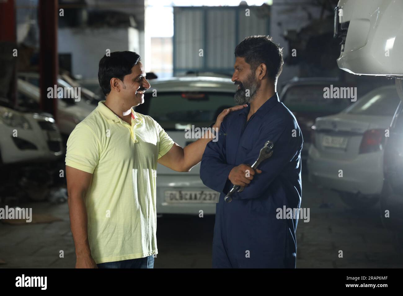 car mechanic standing with the happy customer shaking hands together ...