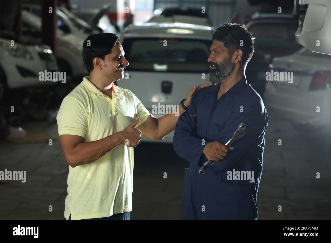 car mechanic standing with the happy customer shaking hands together ...