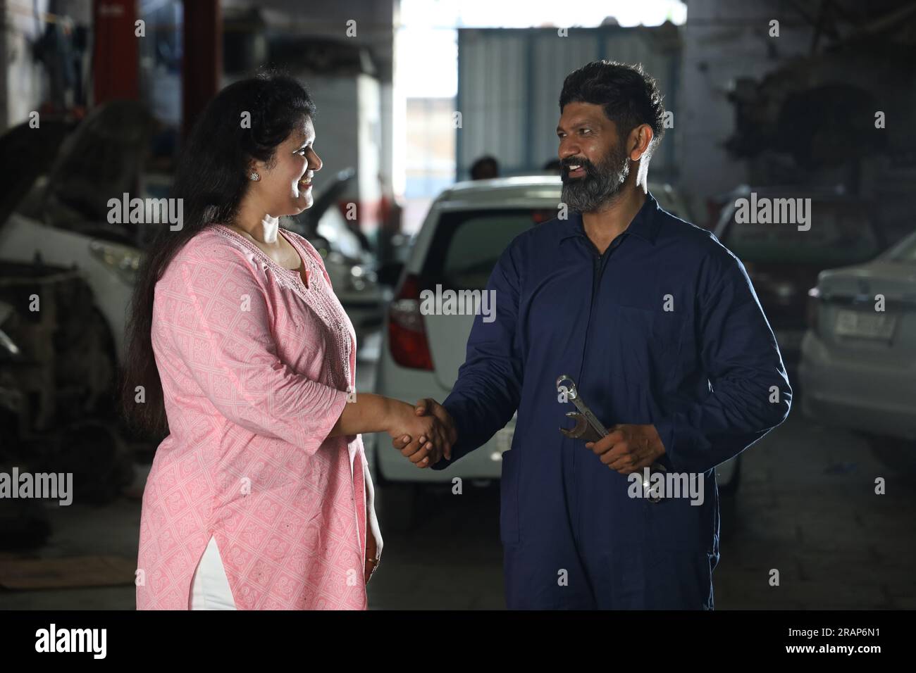 car mechanic standing with the happy customer shaking hands together ...