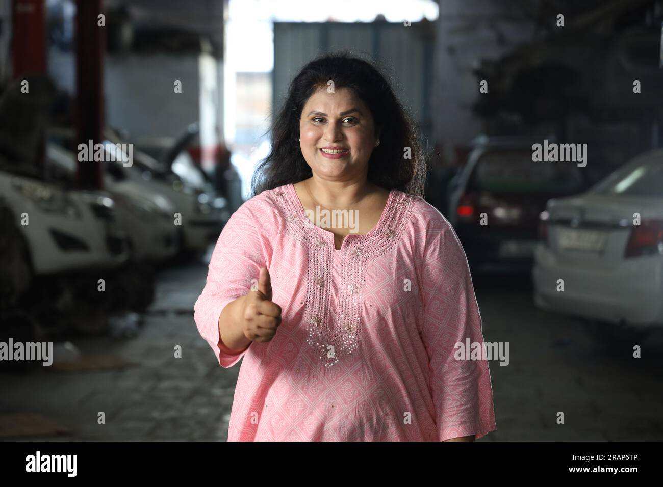 Indian happy female customer showing a thumbs up for repairing the car ...