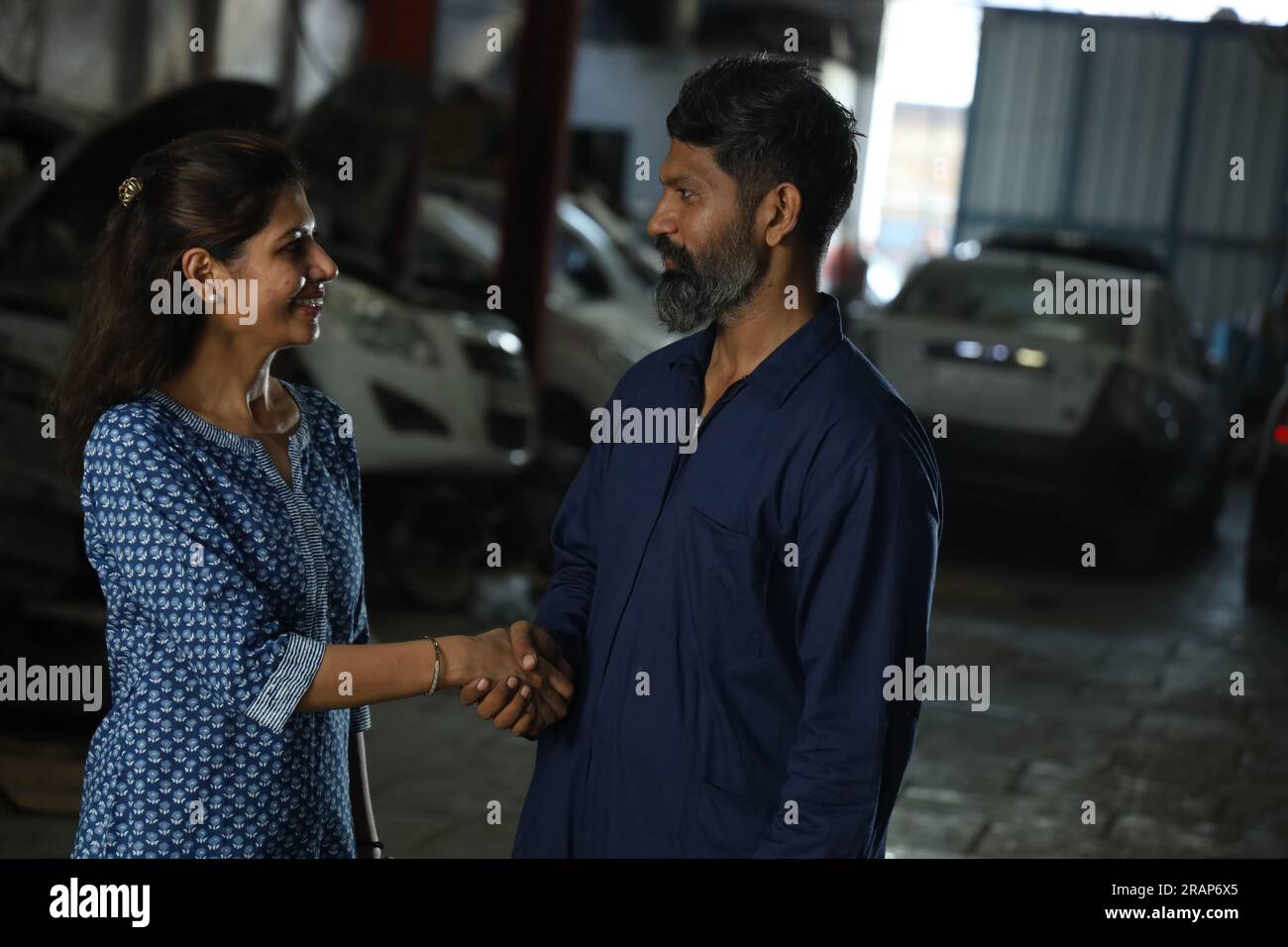 car mechanic standing with the happy customer shaking hands together ...