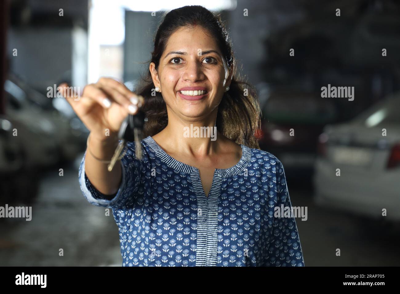Indian happy customer giving the car keys to the mechanic. Portraying ...