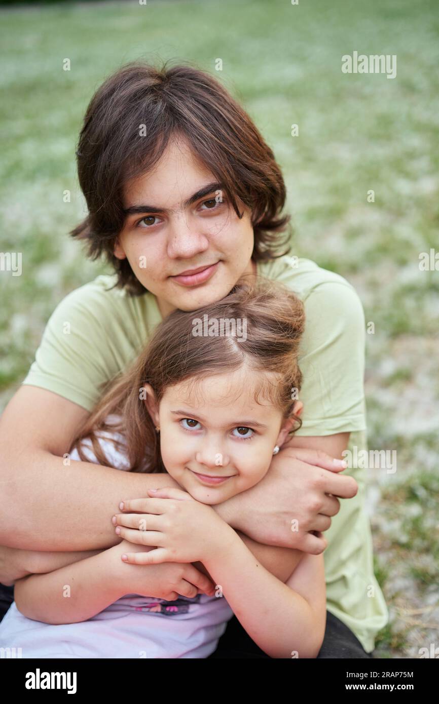 Brotherhood, sisterhood, siblings, family concept. Loving cheerful boy brother hugging his ...