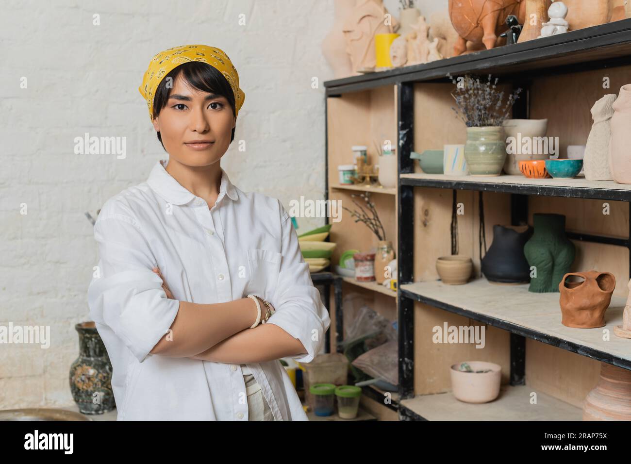 Portrait of young asian female artisan in headscarf and workwear ...