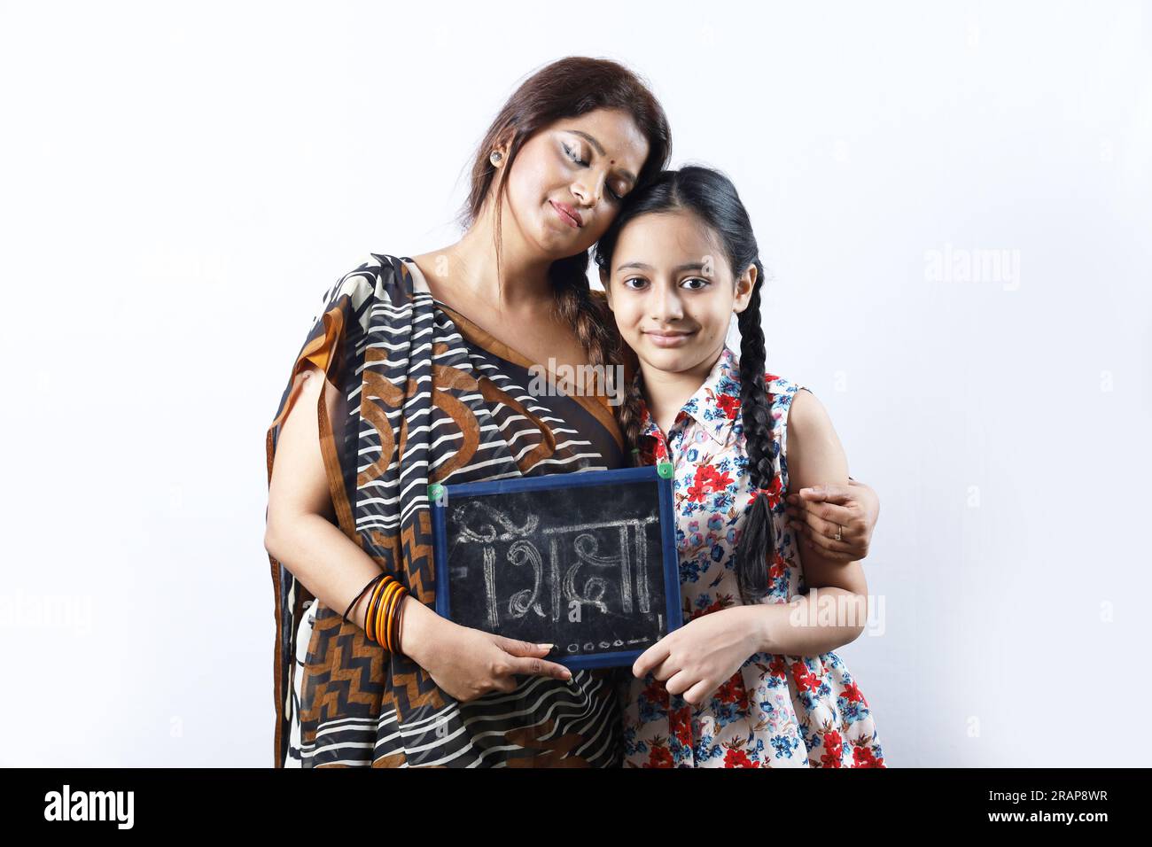 Young Rural Indian Mother And Daughter Holding A Writing Board In Hand