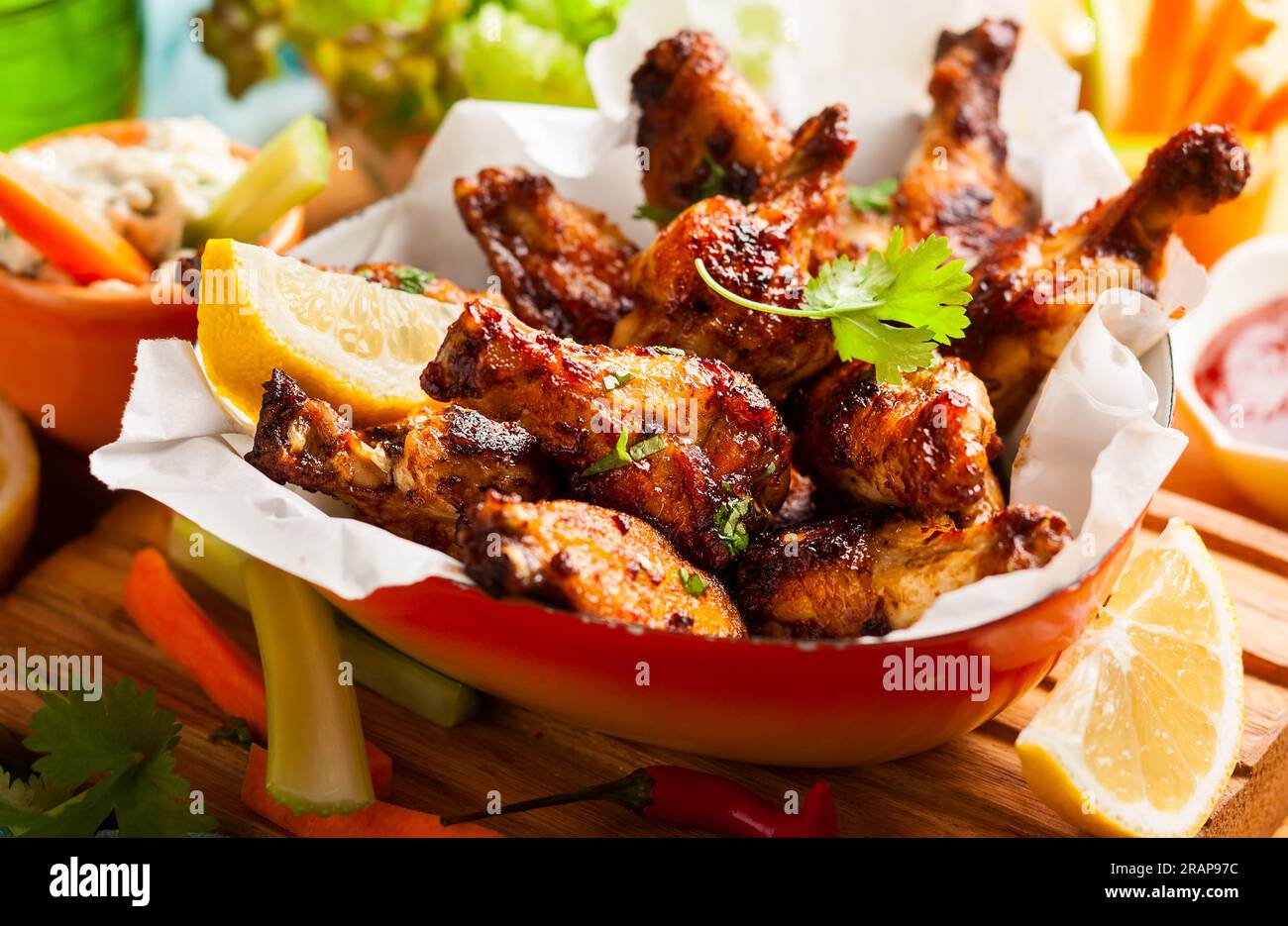 Delicious barbecue chicken wings with two sauces and carrot with celery ...