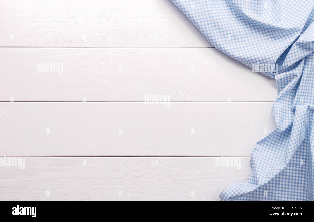 White wooden table with blue checkered table cloth, background with ...